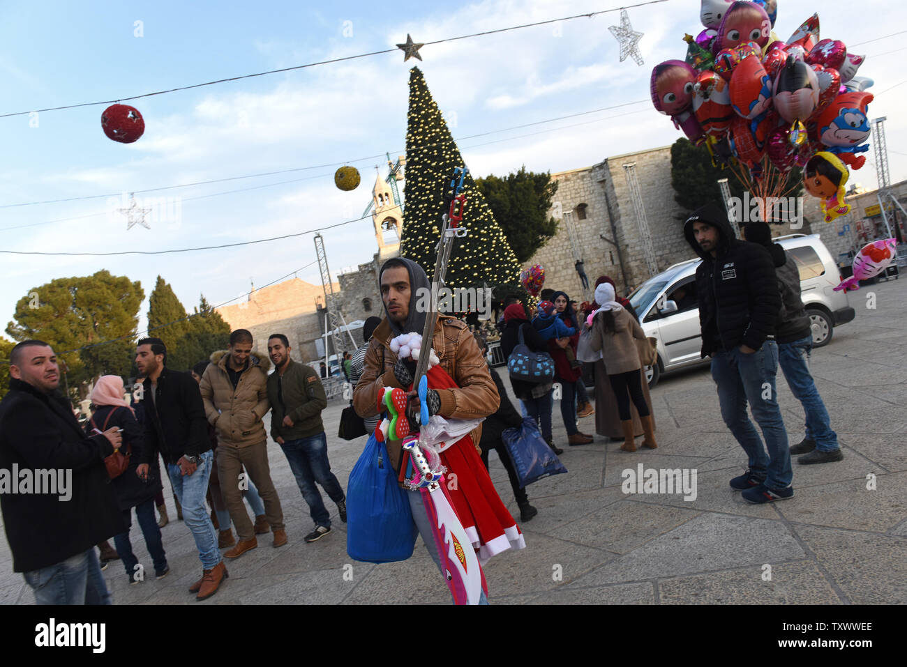 A Palestinian sells Santa hats outside the Church of Nativity, where ...