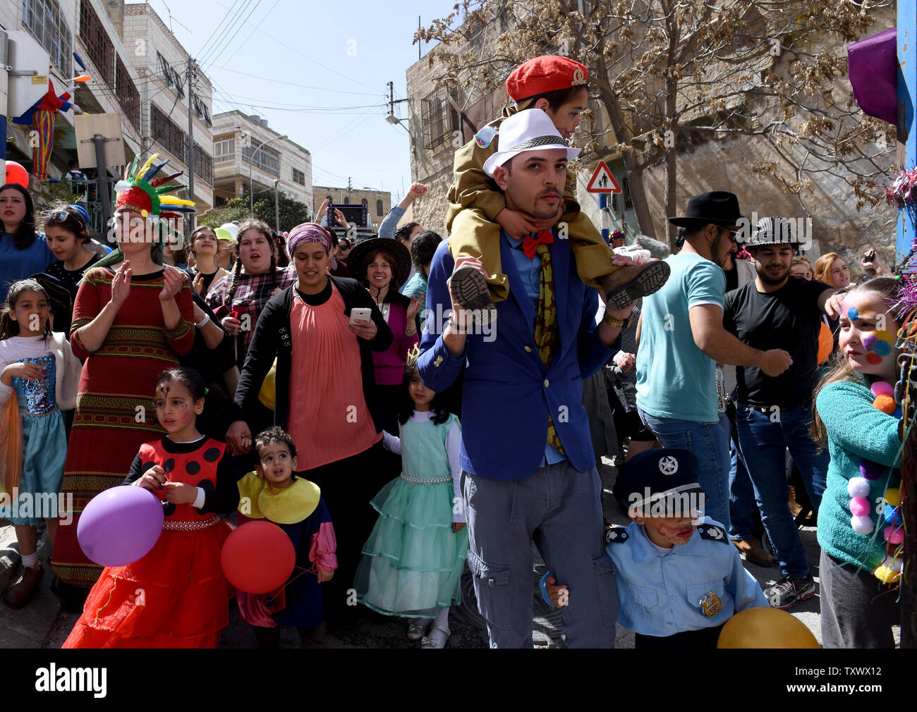 Israeli settlers wear costumes as they participate in the annual Purim ...