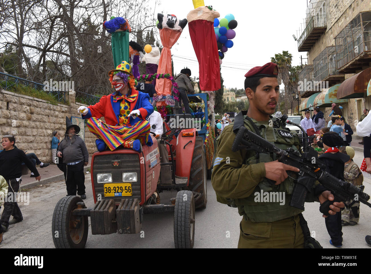 An Israeli soldier guards Jewish settlers wearing costumes in the ...