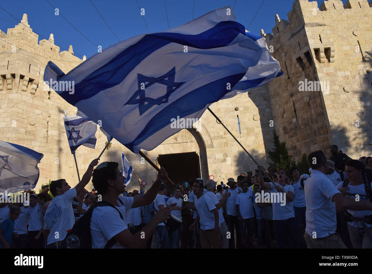 Right-wing Israelis wave national flags as they enter the Damascus Gate ...