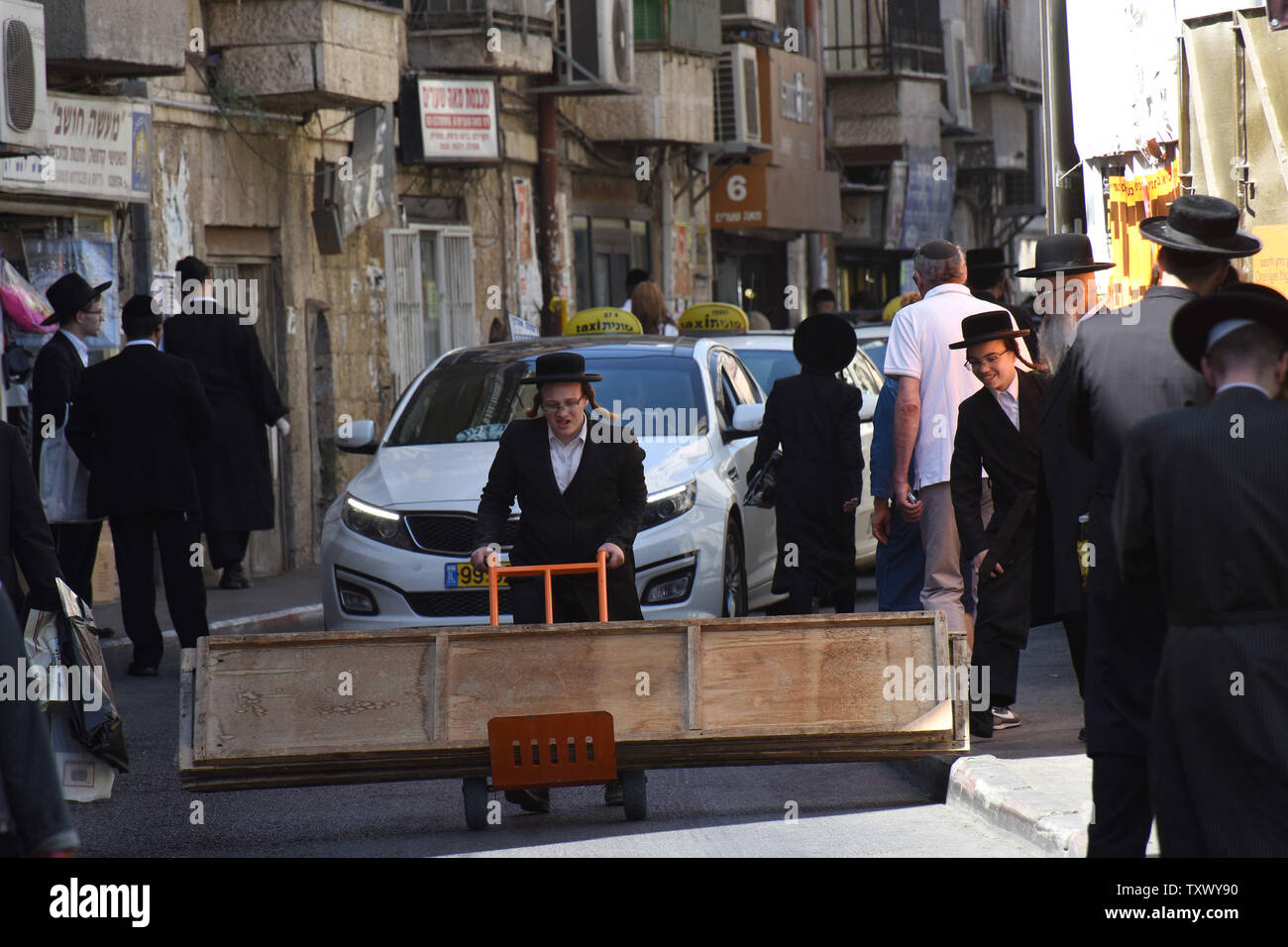 An Ultra-Orthodox Jew carries wood on a cart for the sukkah, a ...