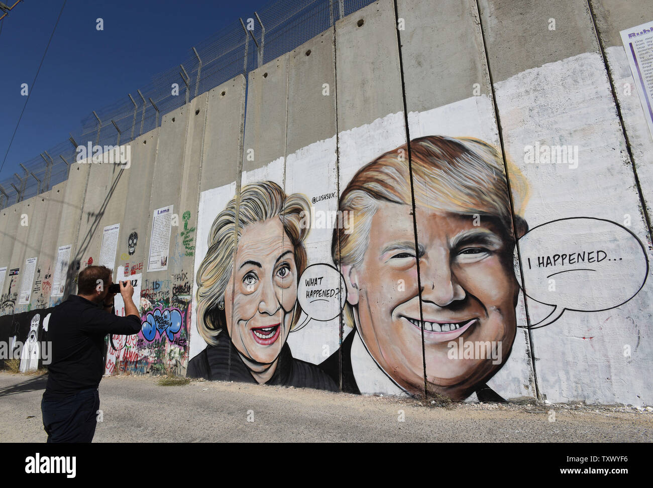 A tourist takes a photo of political graffiti by Austrian artist ...
