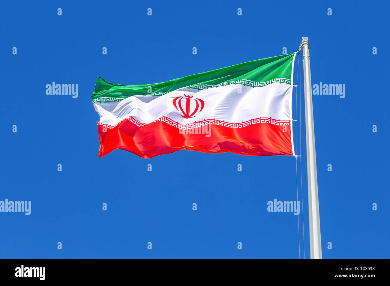 Flag of Iran waving in the wind against the blue sky background Stock ...