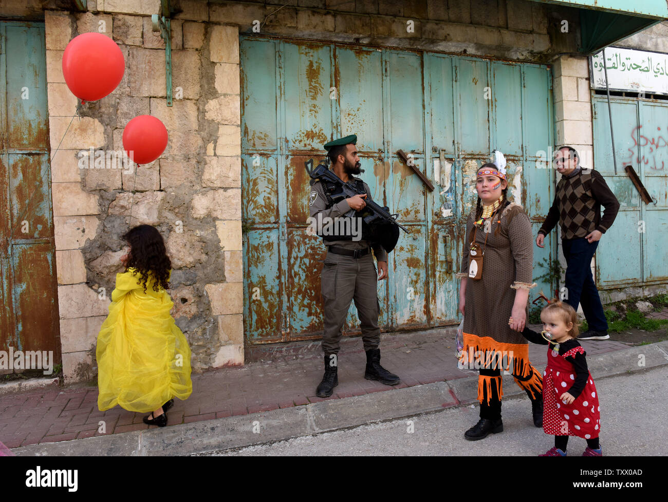 An Israeli border police guards settlers dressed in costumes during the ...