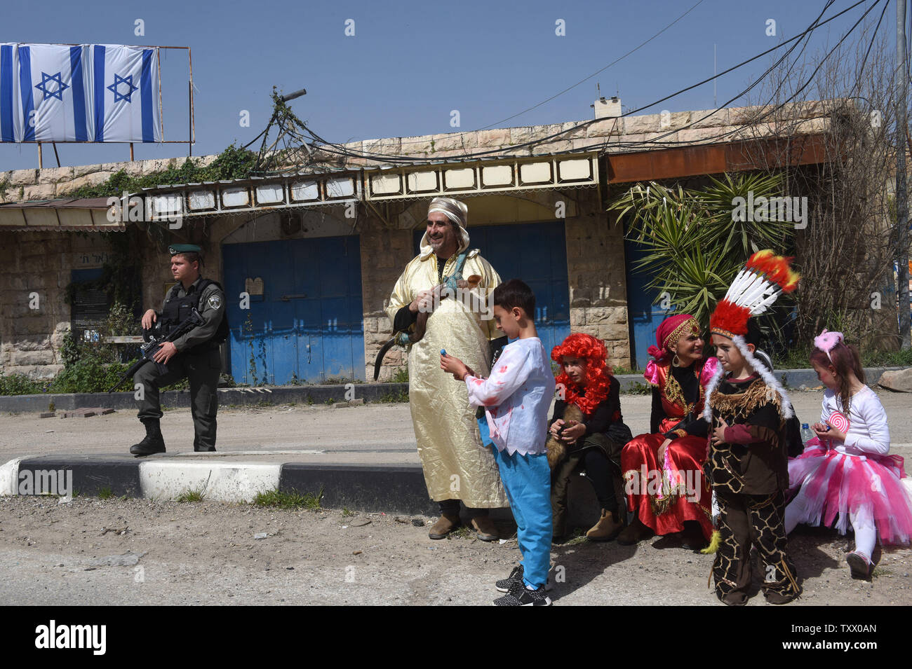 An Israeli border police guards settlers dressed in costumes during the ...