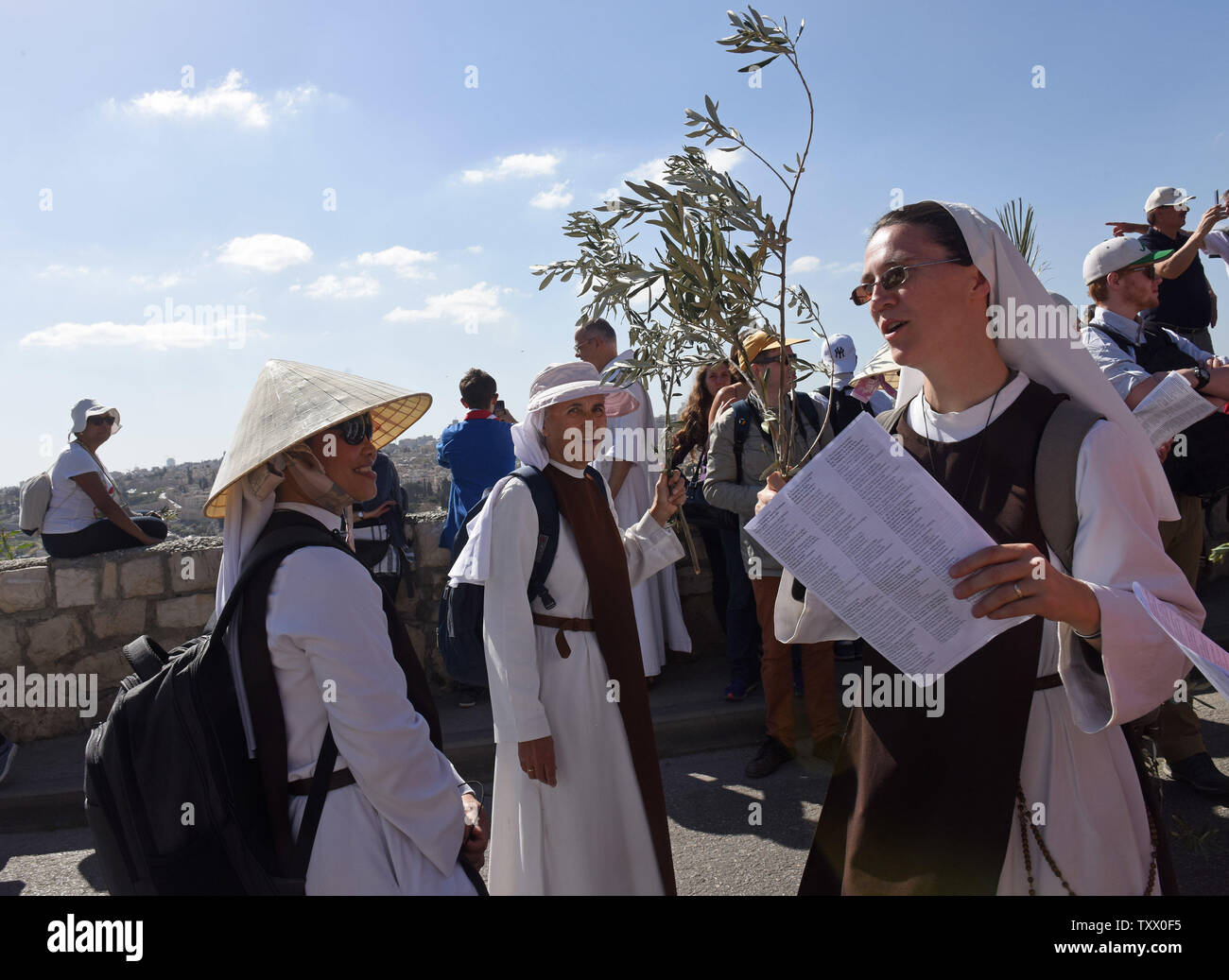 A nun carries an olive branch during the annual Palm Sunday procession ...