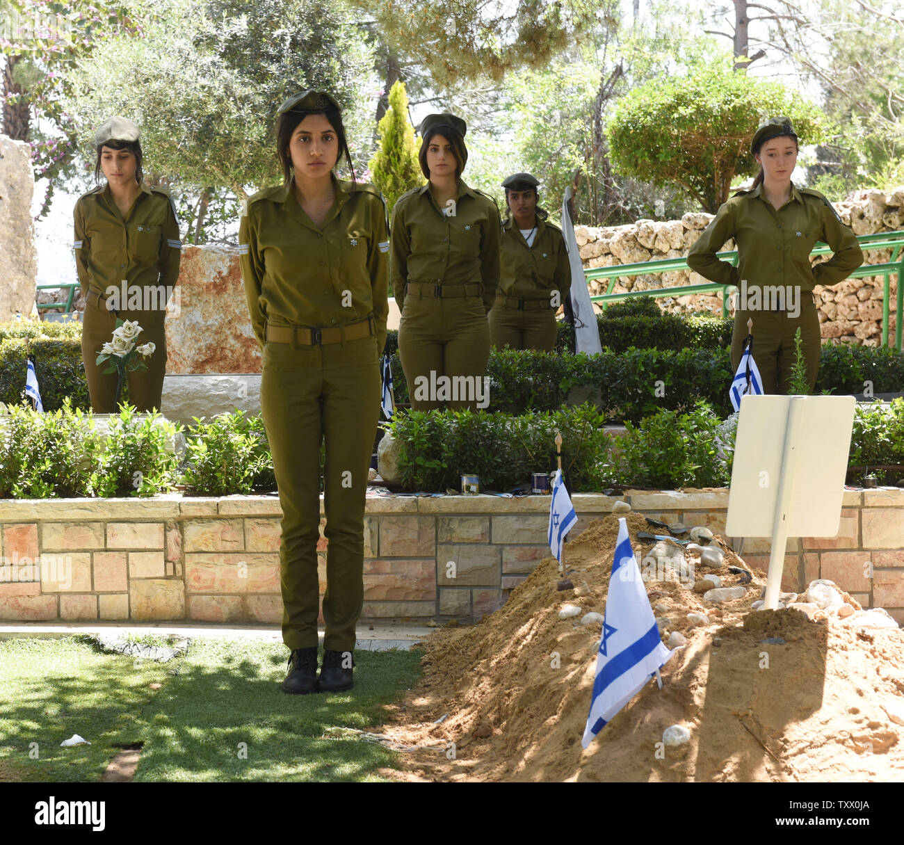 Israeli soldiers stand by the grave of fallen soldiers before Israeli ...