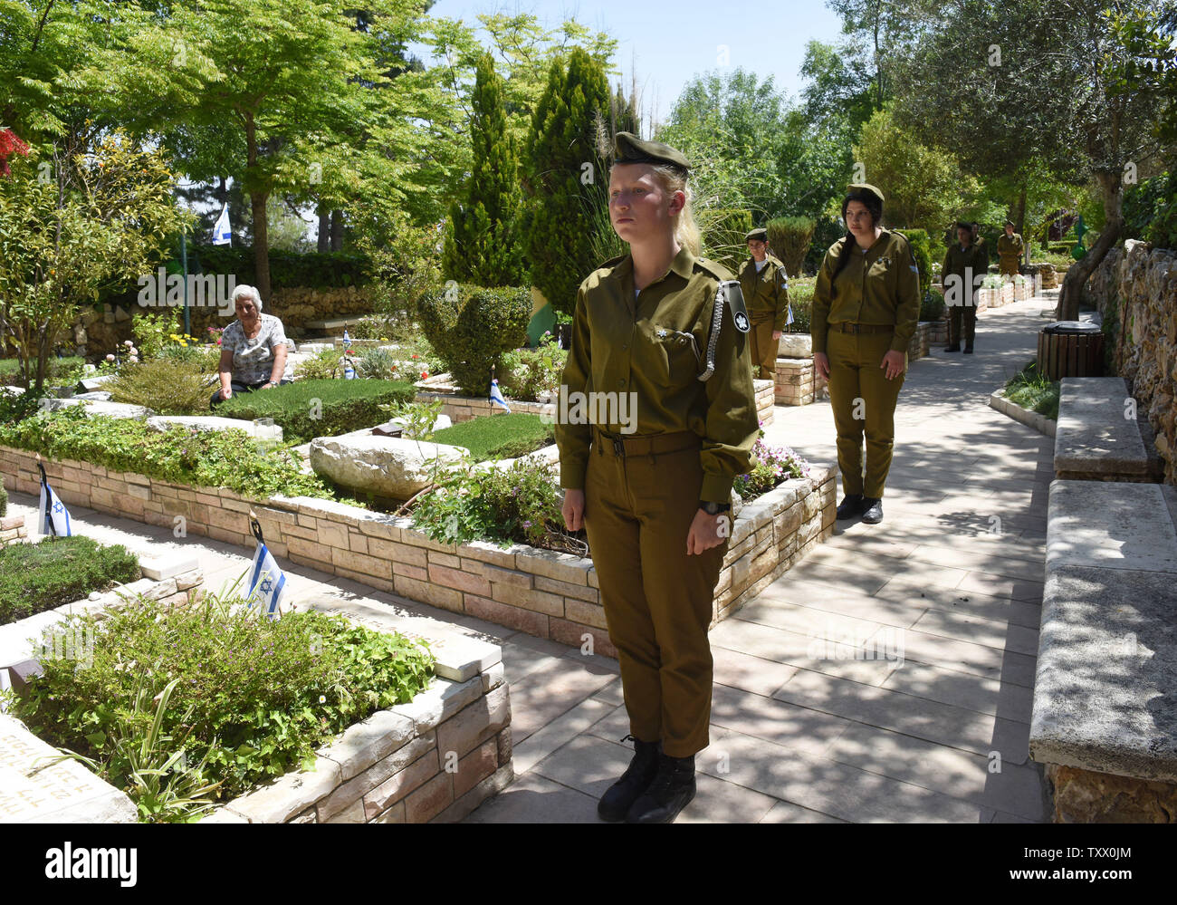 Israeli soldiers stand by the graves of fallen soldiers after placing ...