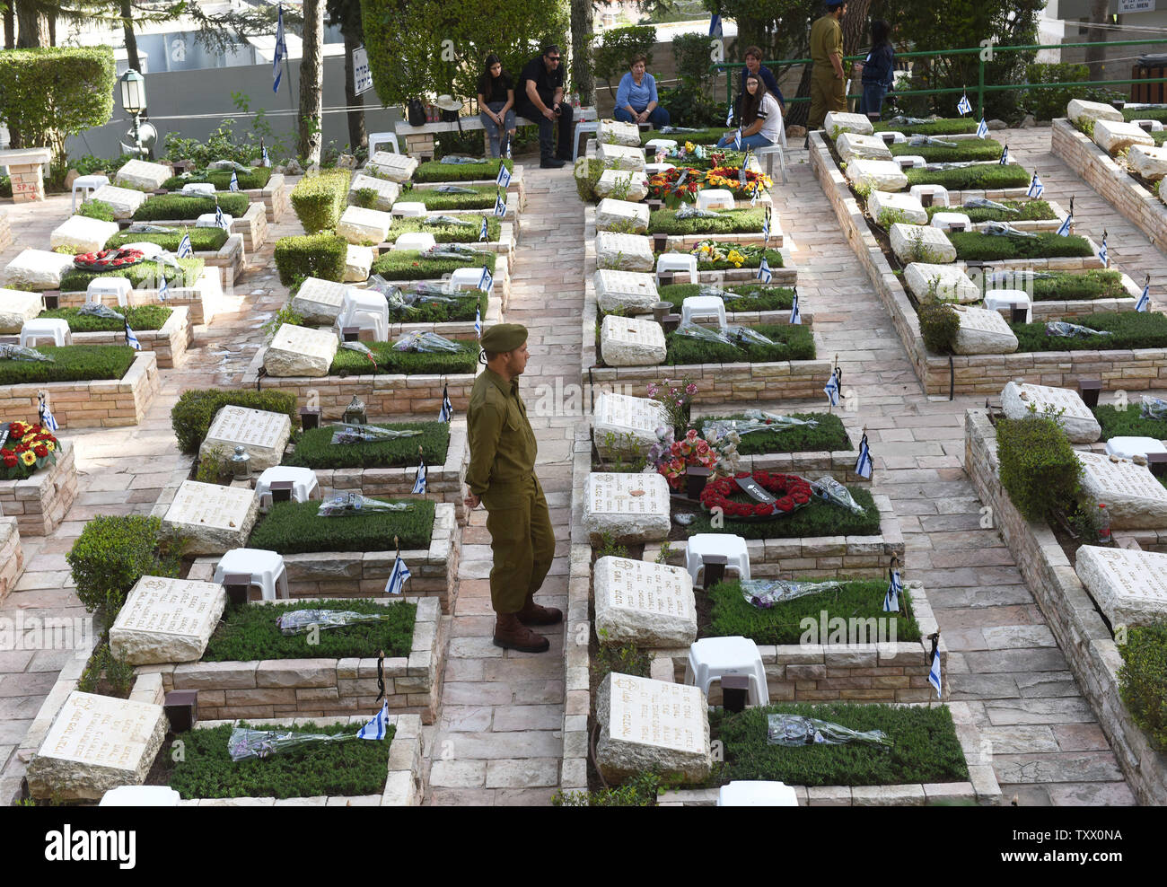 An Israeli soldier stands by graves of fallen soldiers on Israel's ...