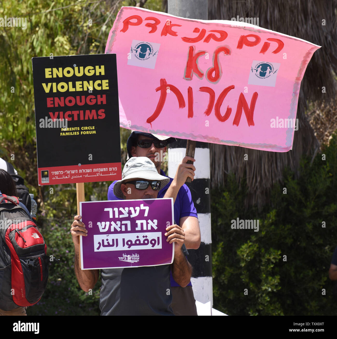 Israeli protesters hold signs calling on the government to stop the ...