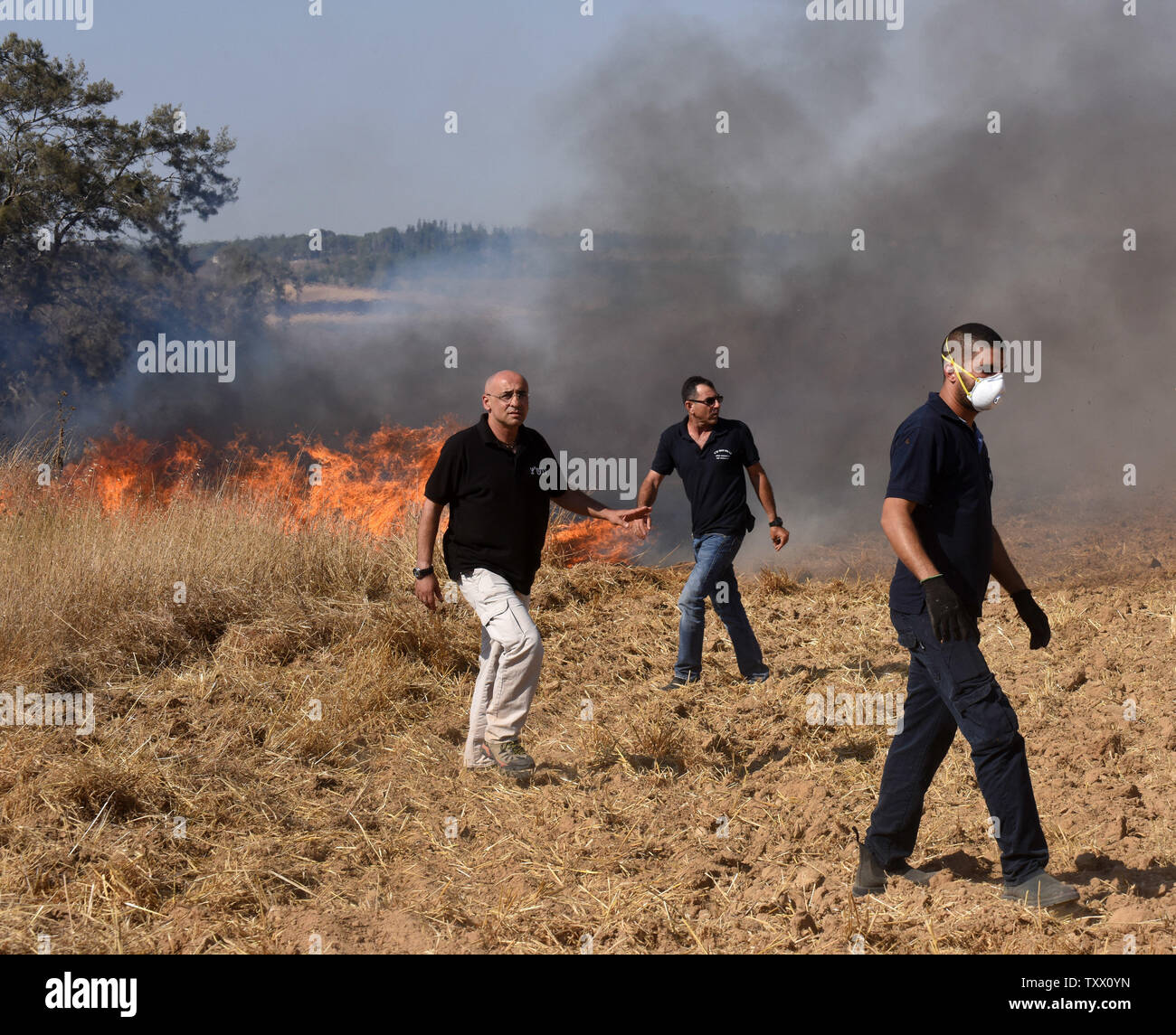 Israelis rush to a fire near Kibbutz Kfar Azza, along the border of the ...