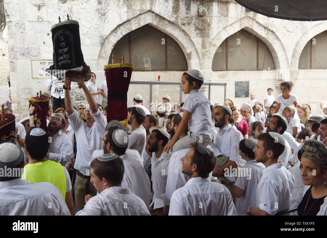 Orthodox Jewish settlers dance and sing with Torah scrolls on Simchat ...