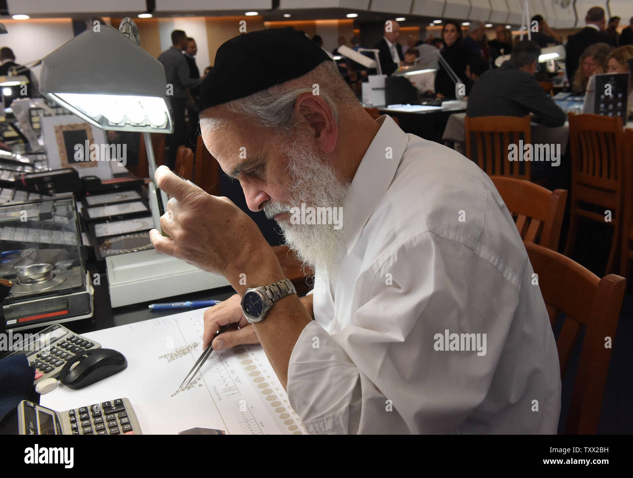 An Orthodox Jewish diamond merchant picks up a diamond during Israel's ...