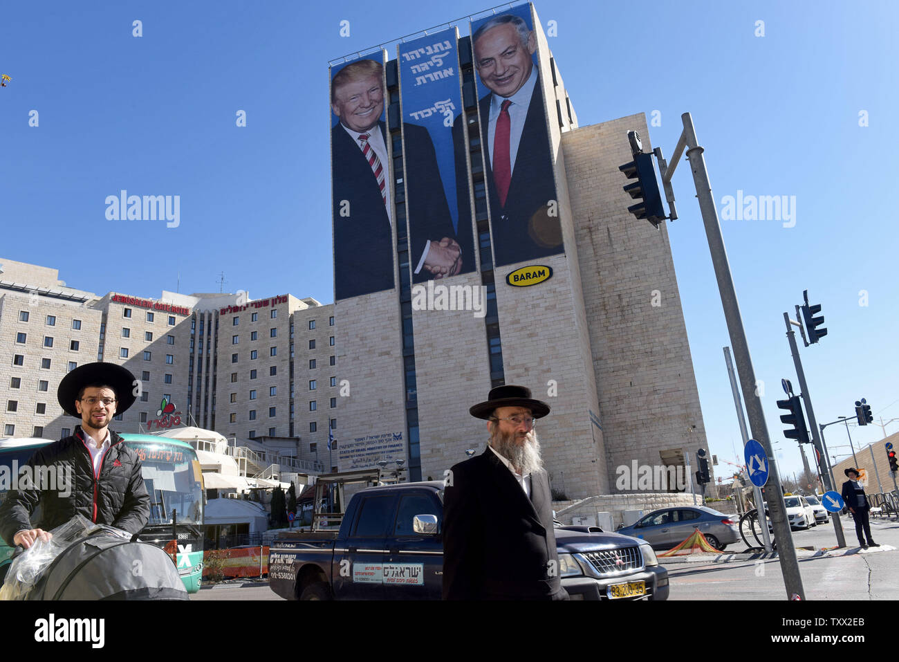 Ultra-Orthodox Jews walk past a giant election campaign billboard of U ...