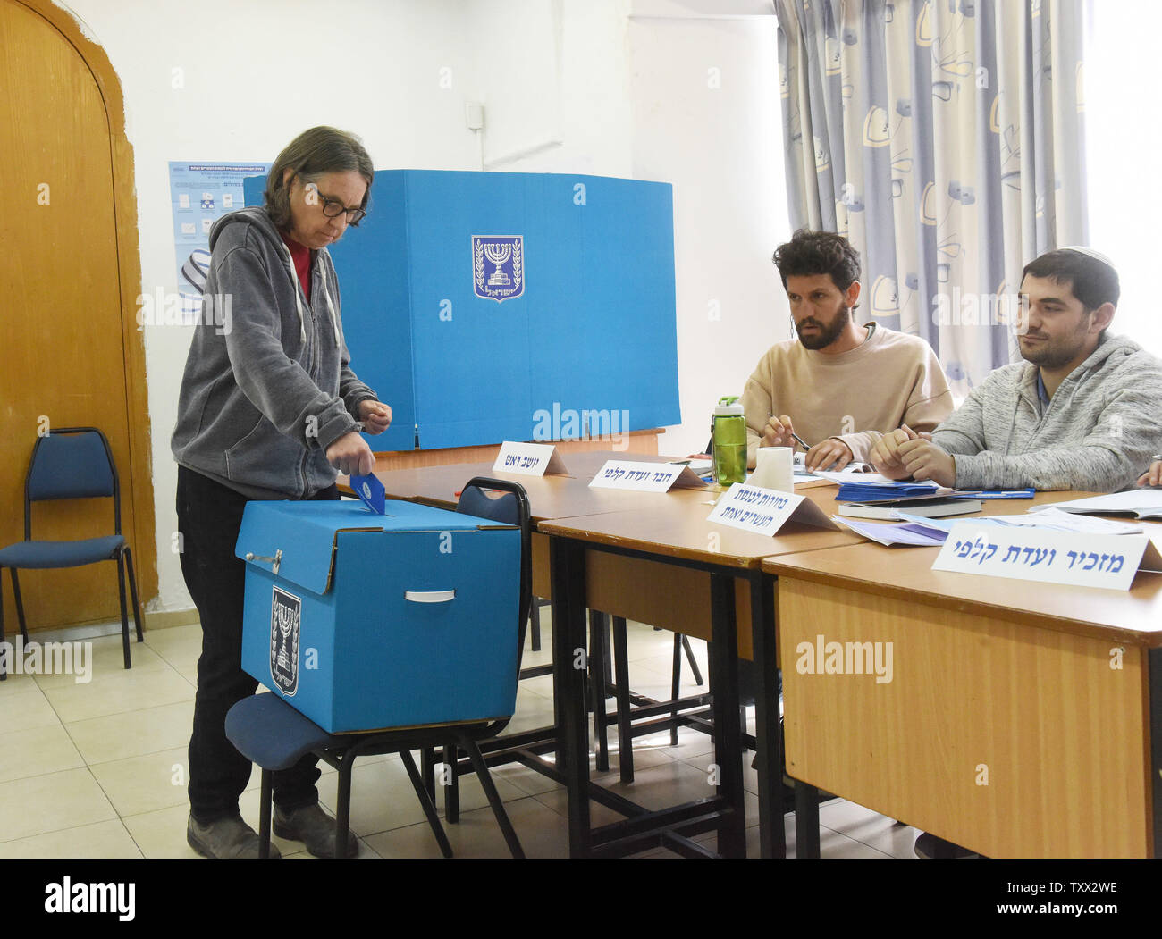 An Israeli leaves a voting booth to cast her vote in the general ...