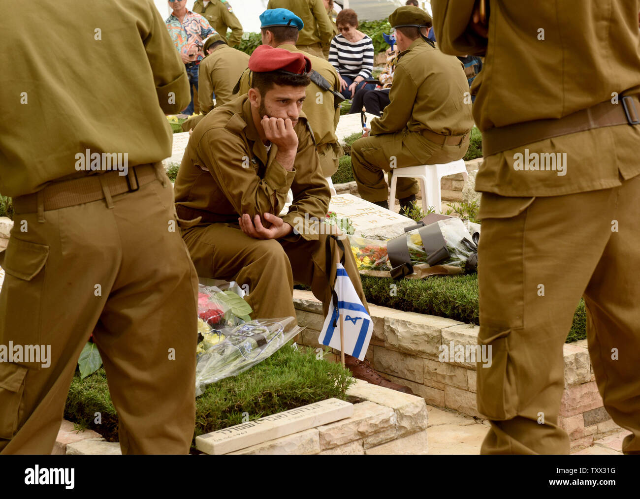 An Israeli soldier sits by the graves of fallen soldiers in the Mt ...