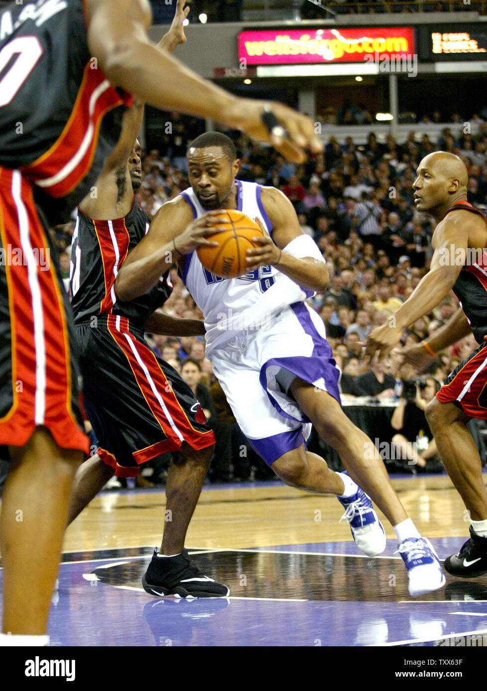 Kenny Thomas from the Sacramento Kings drives past 3 Miami Heat ...