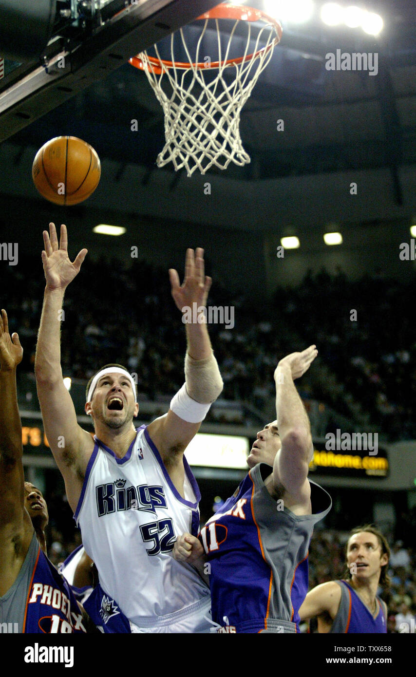 Brad Miller from the Sacramento Kings shoots between, Raja Bell (L) and ...