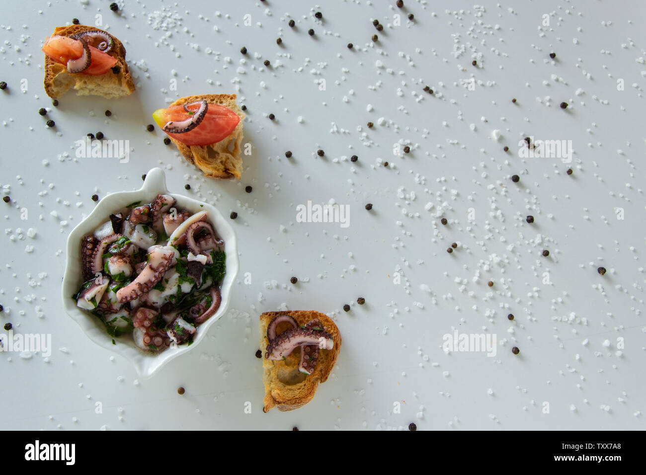 Top view of octopus salad with slices of toasted baguette - bruschetta ...