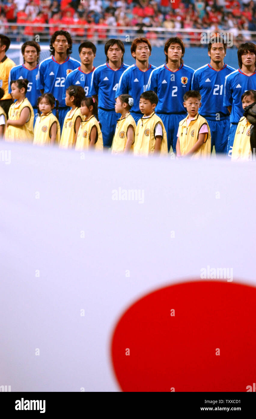 Japanese team members sing their national anthem at the opening ...