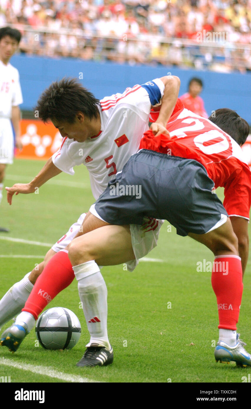 Li Weifeng (DF, L) of China struggles for ball with Lee Dong Gook (FW ...