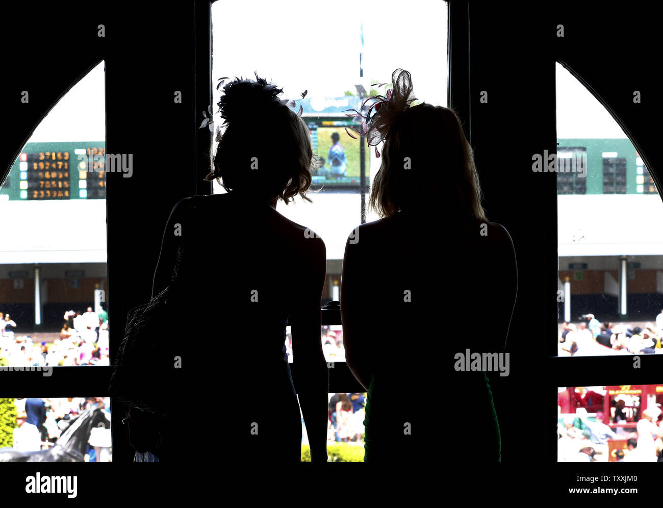 Racing fans watch the paddock at the Kentucky Derby at Churchill Downs ...