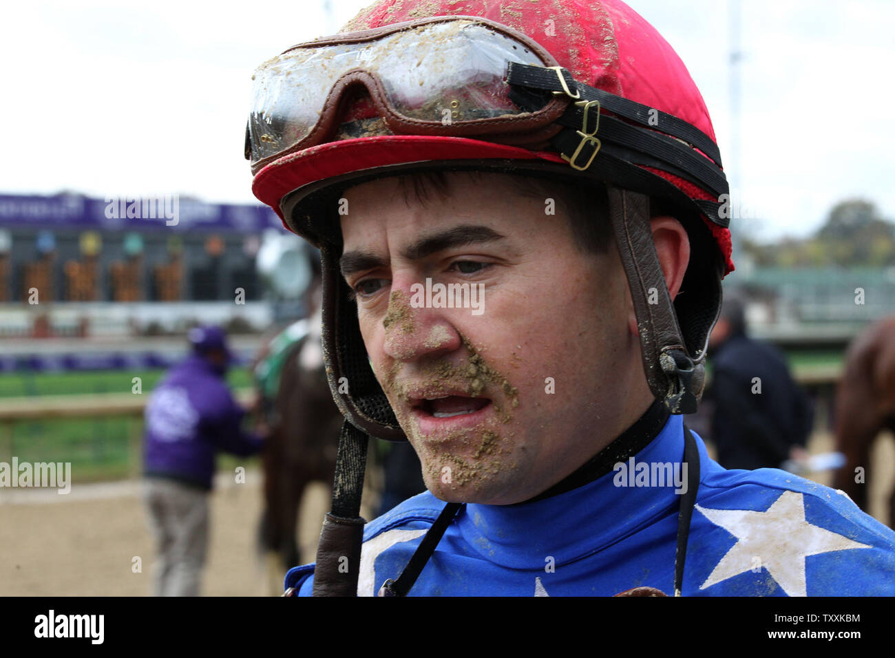 Jockey Brian Hernandez's face is covered in mud after racing in a early ...