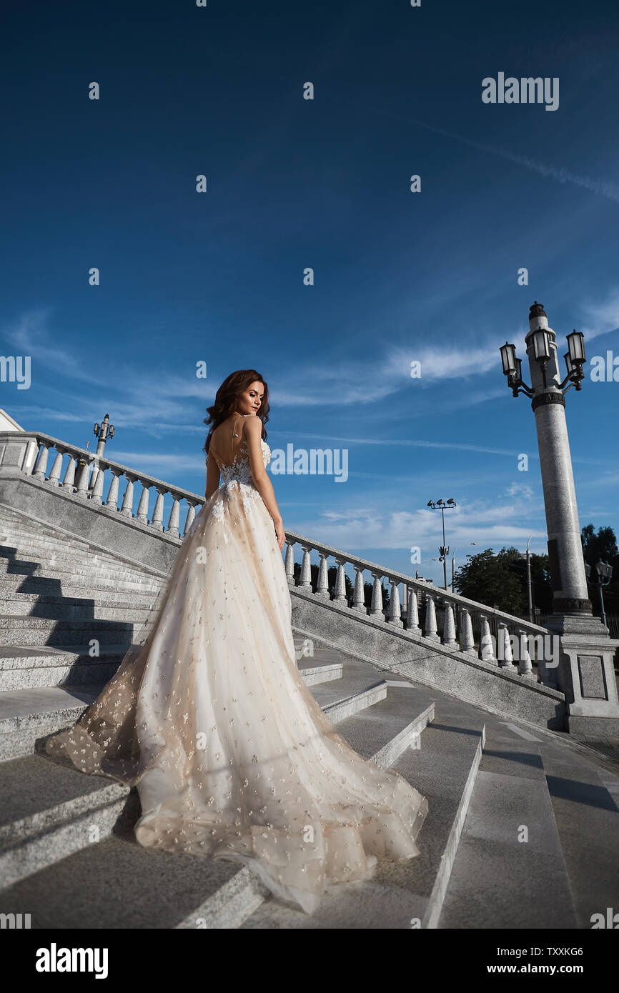 Beautiful model woman with perfect body in luxury wedding dress stands ...