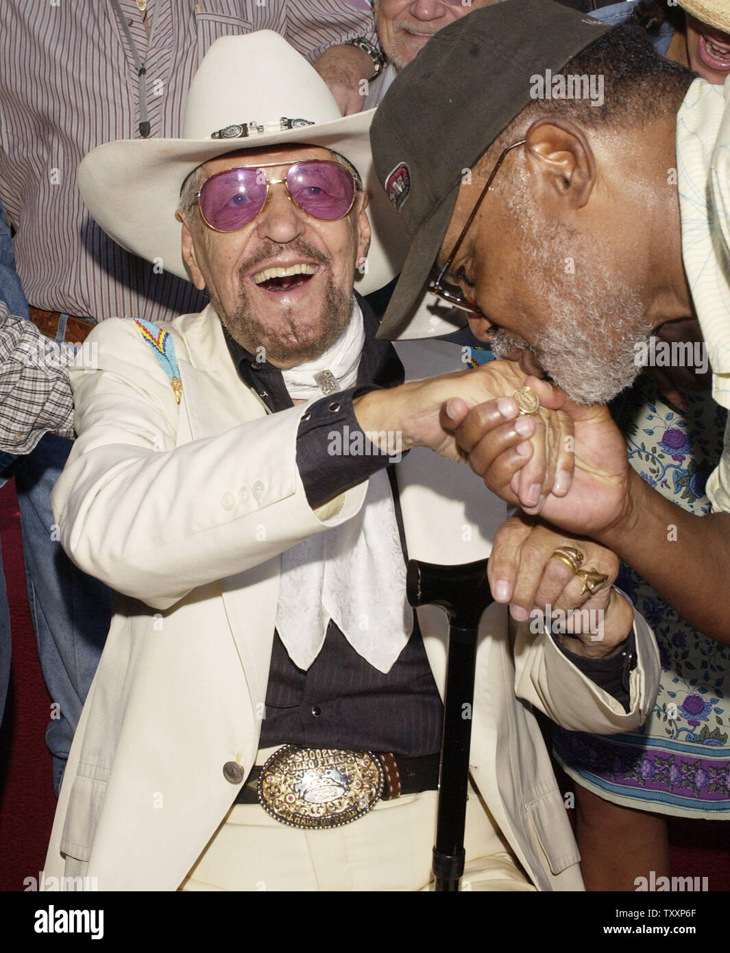 Richard Davis (R) kisses the ring of Herb Jeffries, a singing cowboy ...