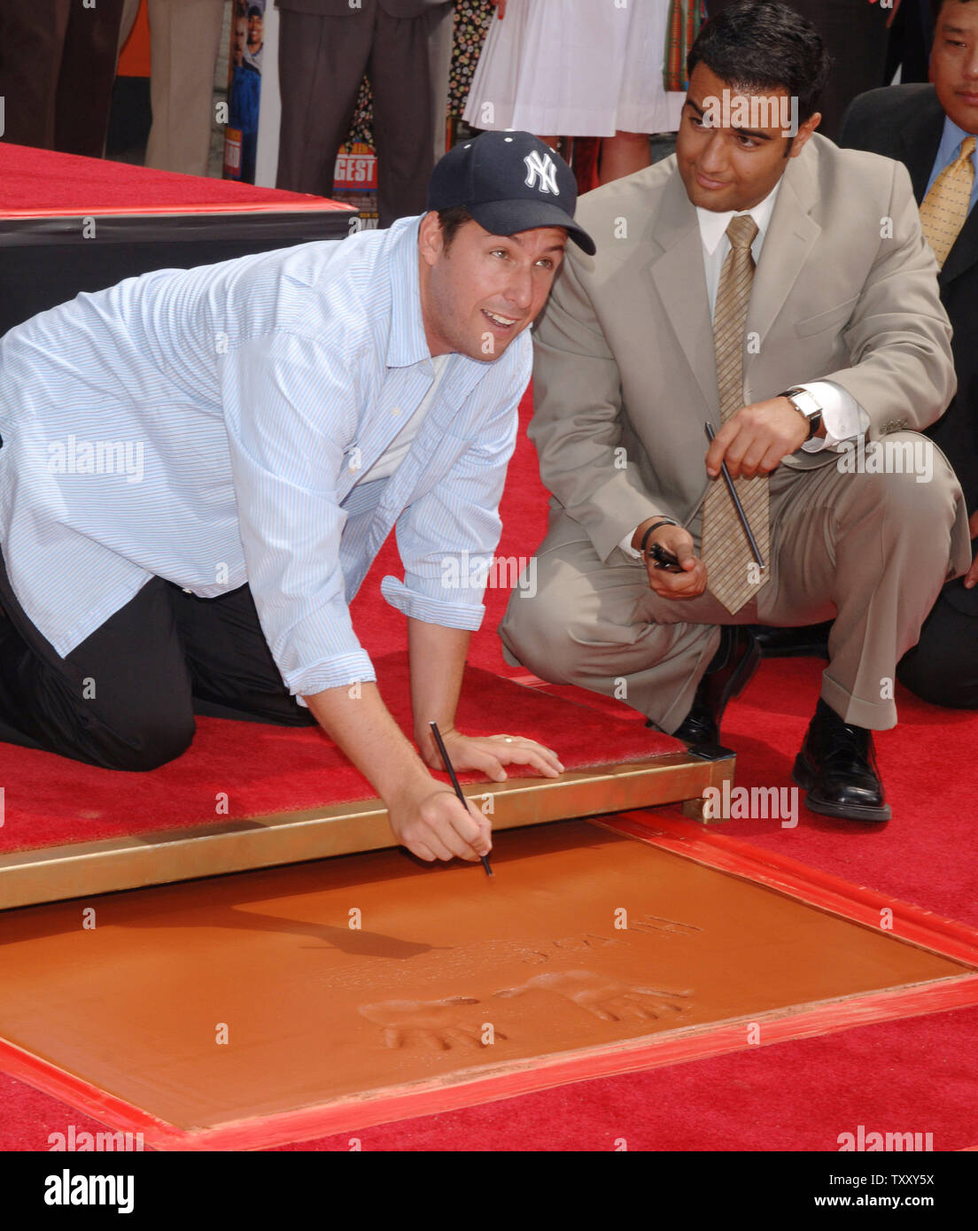 Actor Adam Sandler signs his name in wet cement during a hand and ...