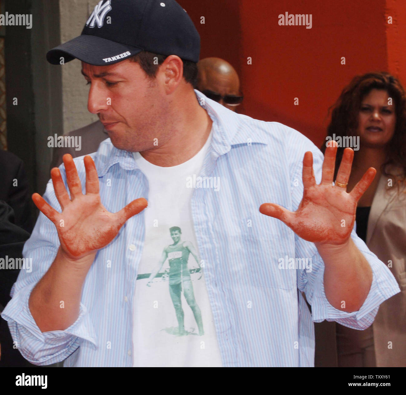 Actor Adam Sandler signs his name in wet cement during a hand and ...