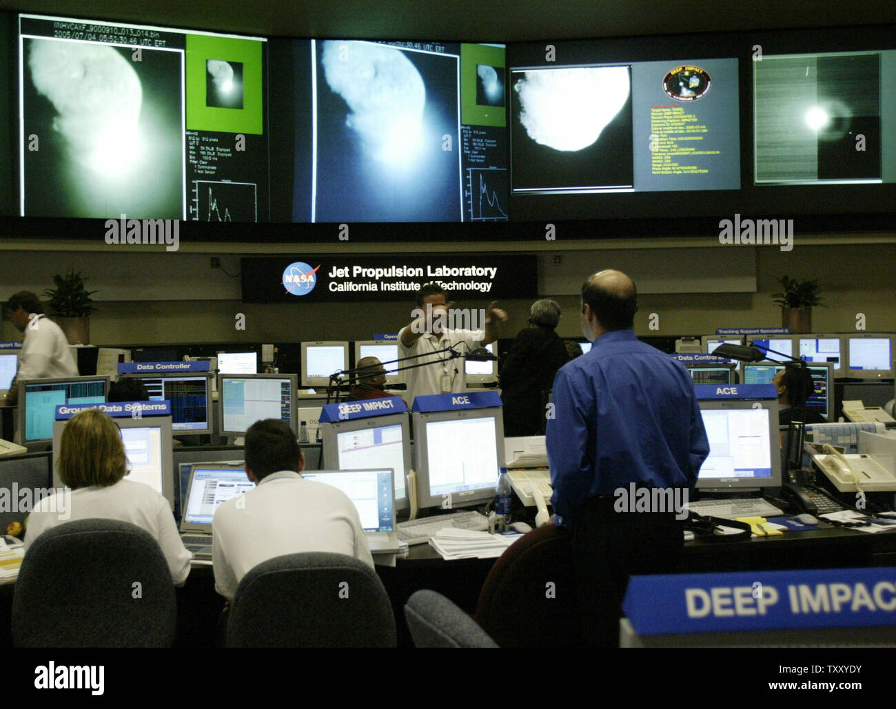 NASA engineers look at images of the successful collision of the Deep ...