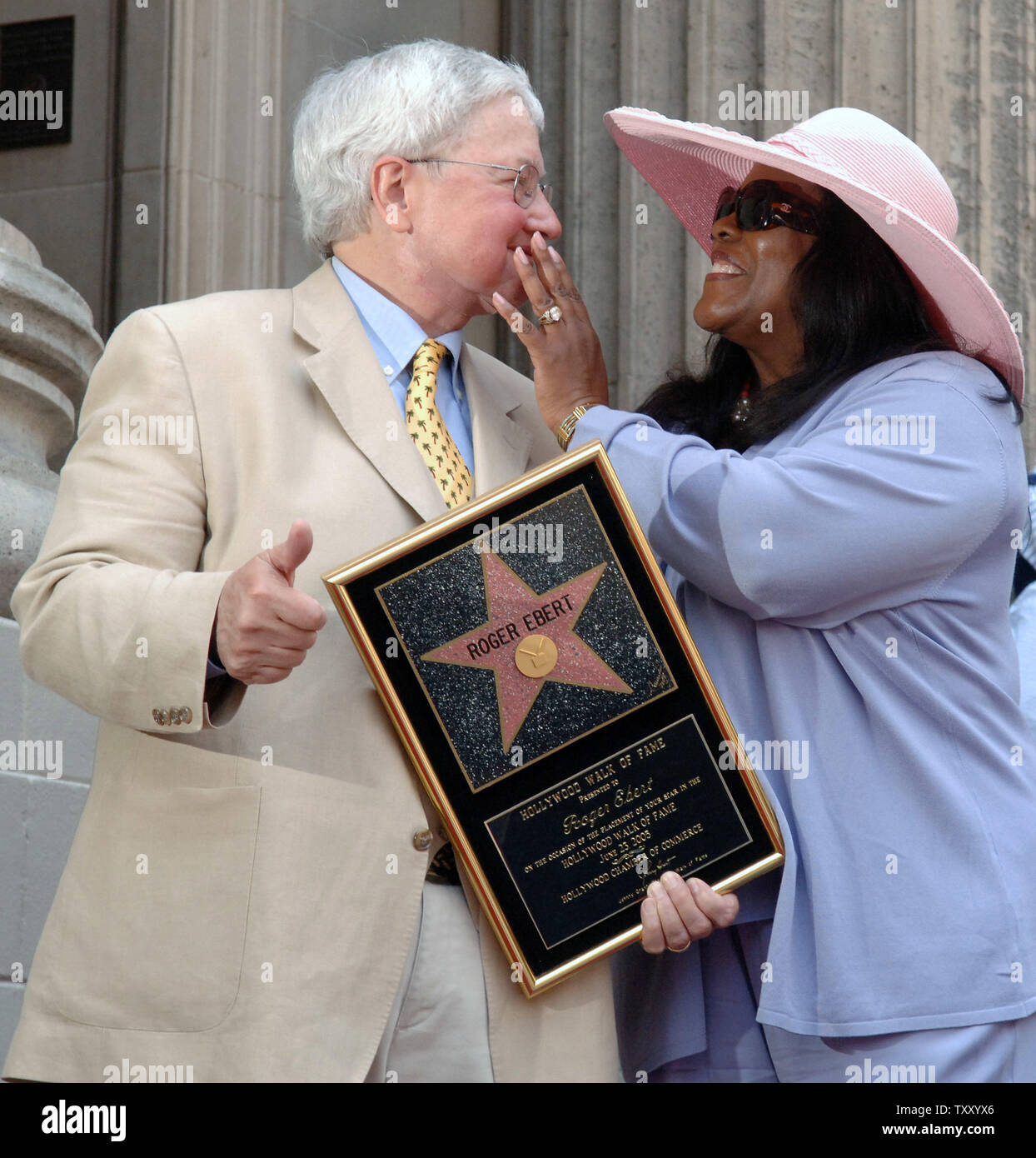 Film critic Roger Ebert gestures with a thumbs up as his wife Chaz ...