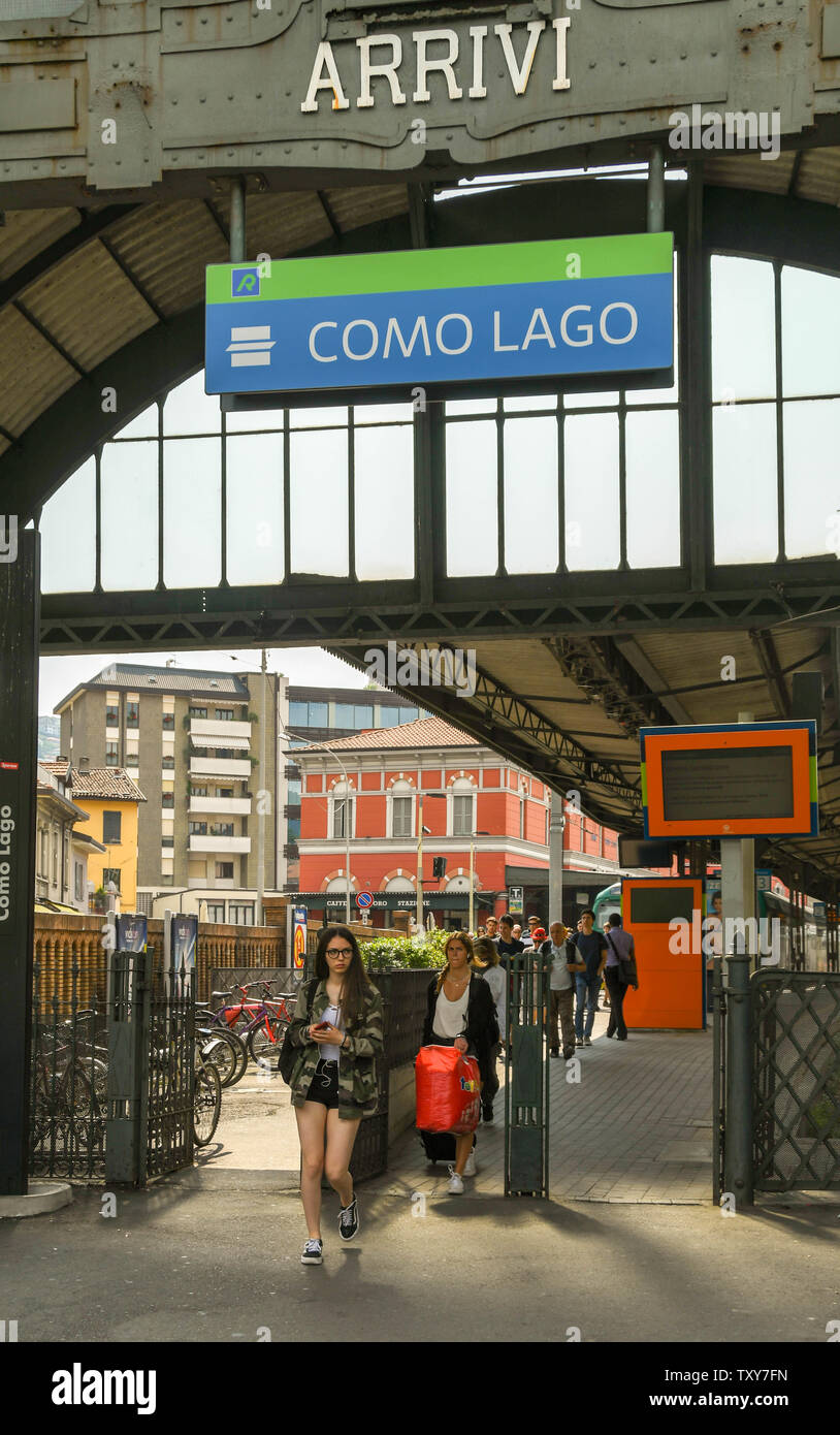 COMO, ITALY - JUNE 2019: People leaving the station entrance after ...