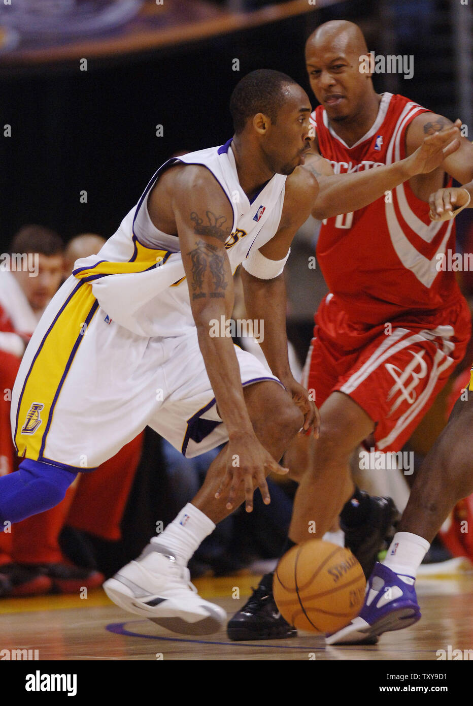 Los Angeles Lakers' guard Kobe Bryant (L) drives around Houston Rockets ...