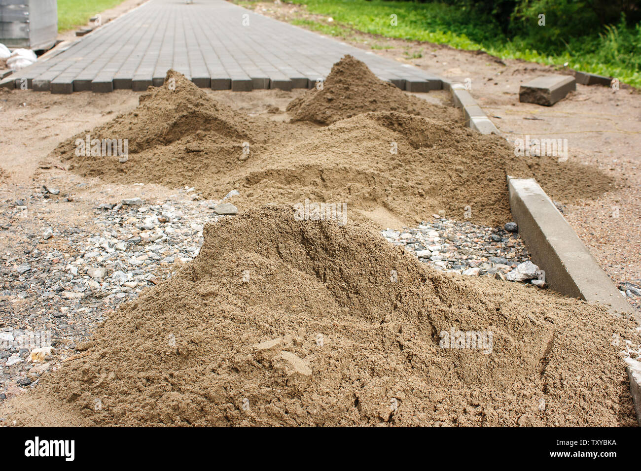 construction of a new road with paving tiles outdoor on summer day ...