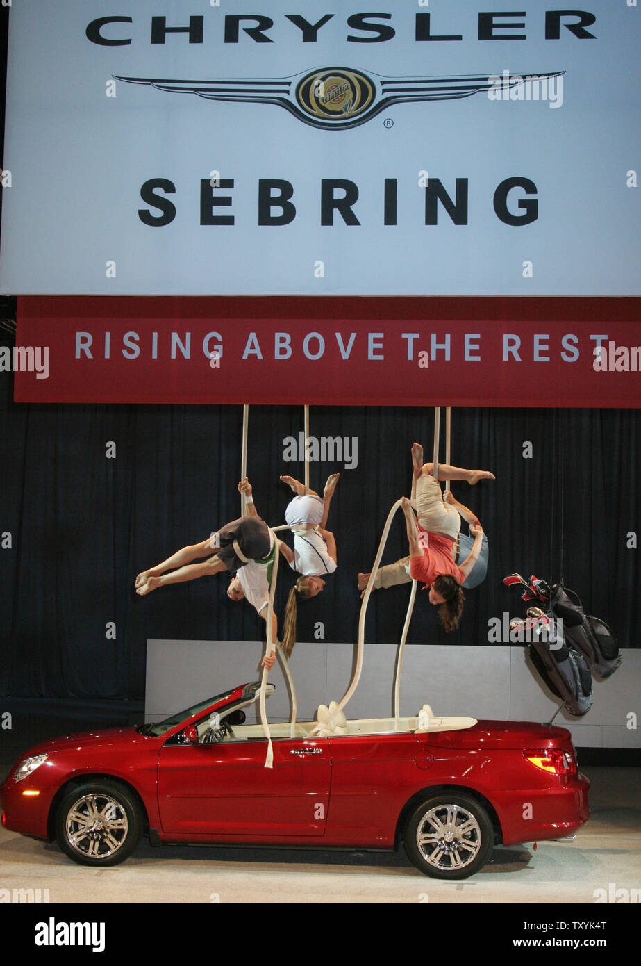 Aerial acrobats are lifted out of the car during a presentation for the ...