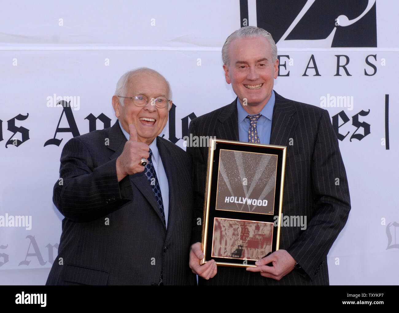 Johnny Grant (L) and publisher David Hiller (R) pose for photographs ...