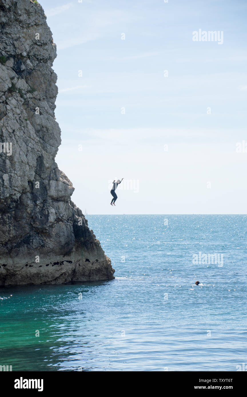 Durdle Door beach where person jumps into sea from cliff Stock Photo ...