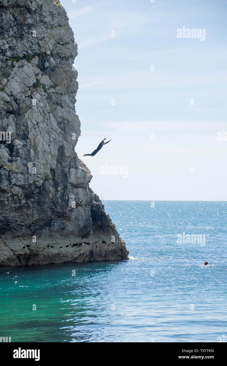 Person Jumping Off Cliff Into Water