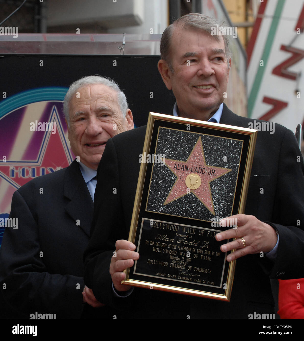 Producer Alan Ladd Jr. (R) holds a replica plaque as he shares a light ...