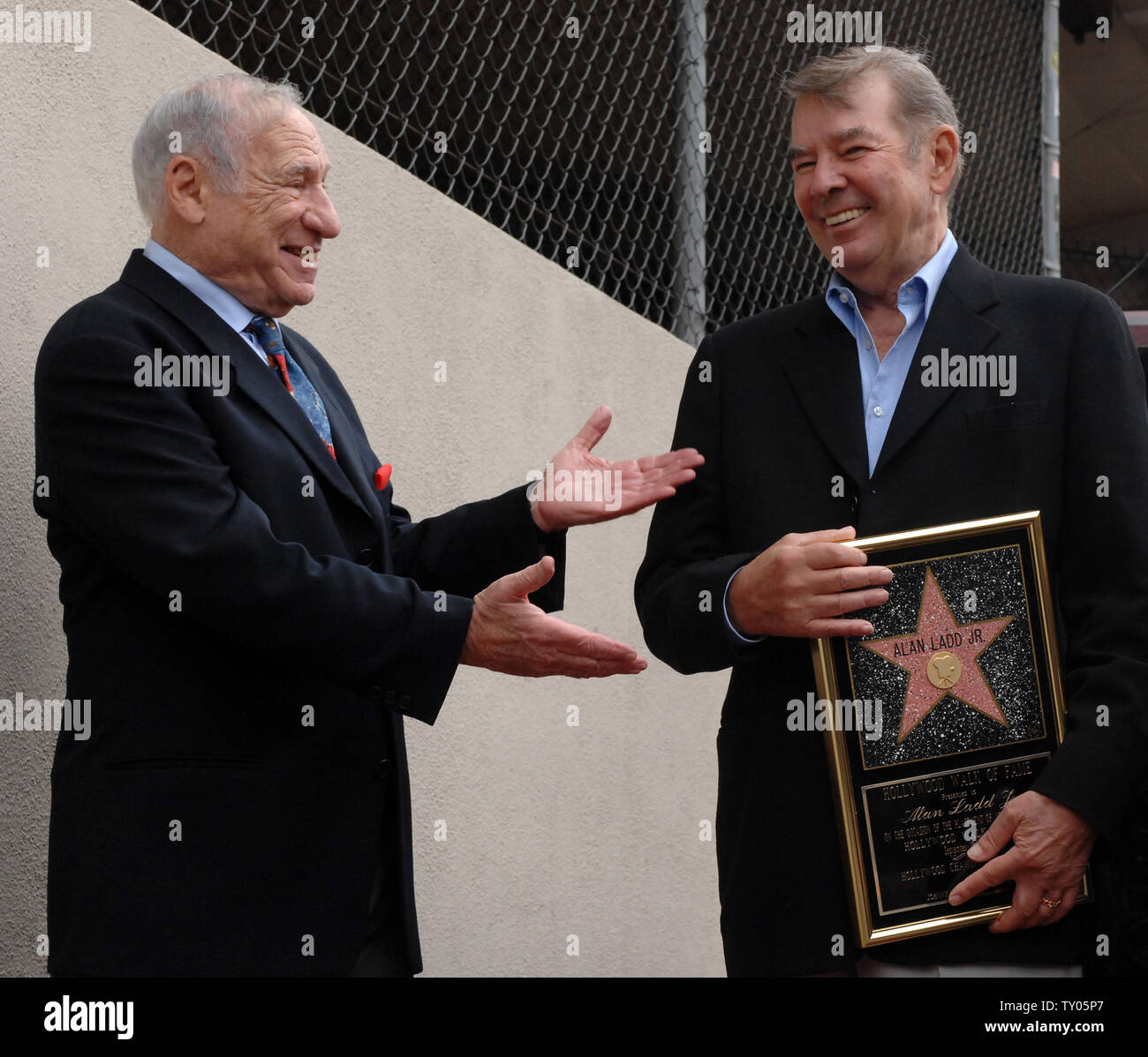 Producer Alan Ladd Jr. (R) holds a replica plaque as he shares a light ...