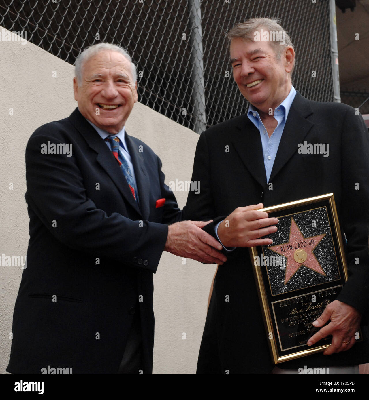 Producer Alan Ladd Jr. (R) holds a replica plaque as he shares a light ...