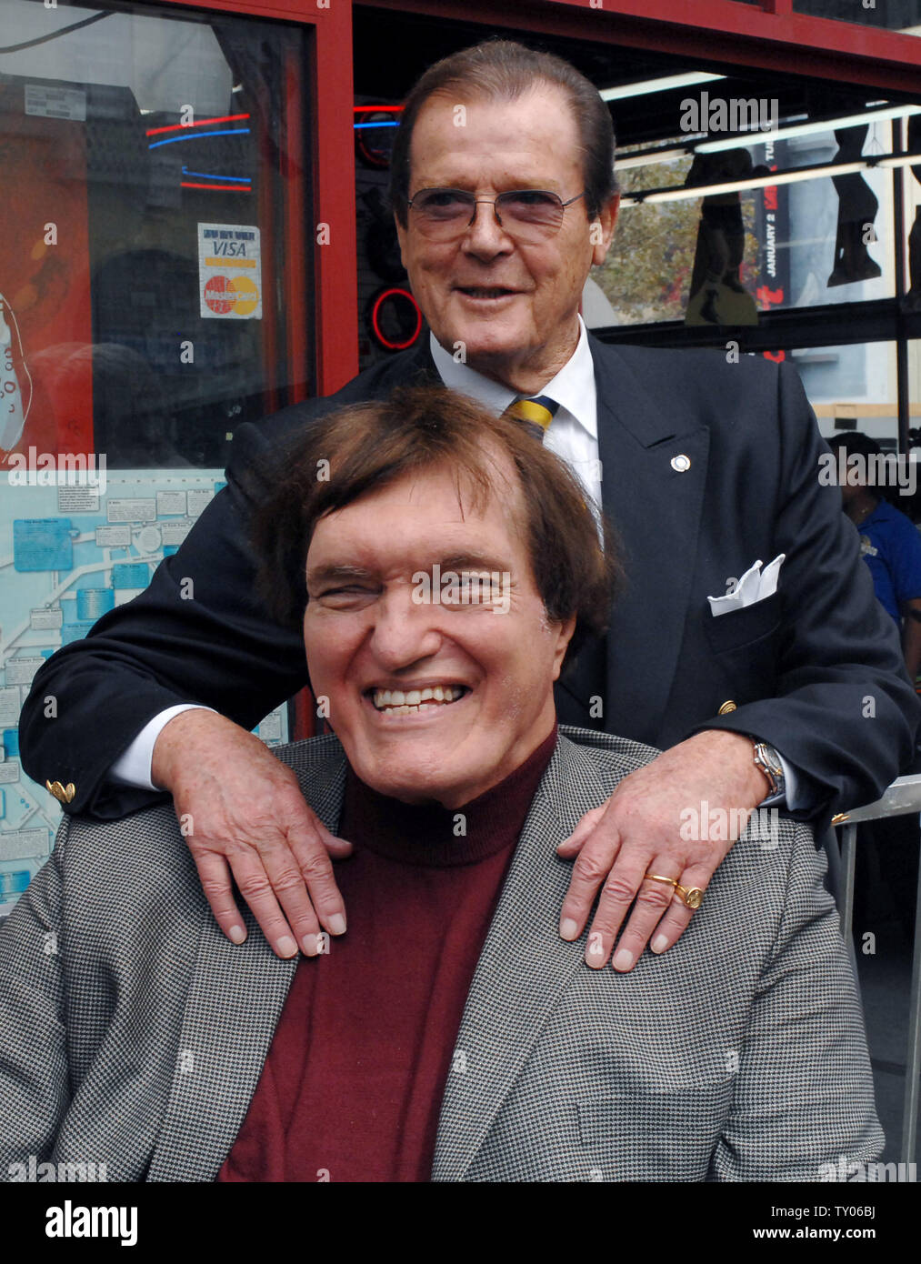 British actor Roger Moore (R) who played the part of James Bond 007 in ...
