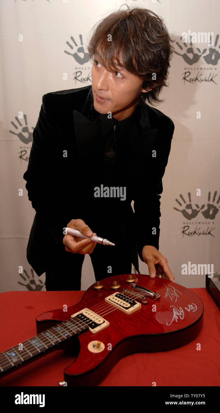 Vocalist Koshi Inaba of the Japanese group B'z autographs a guitar ...