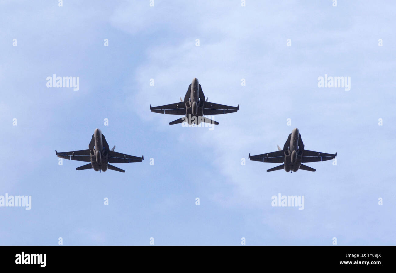 A trio of United States Navy Hornet aircraft perform a flyover during ...