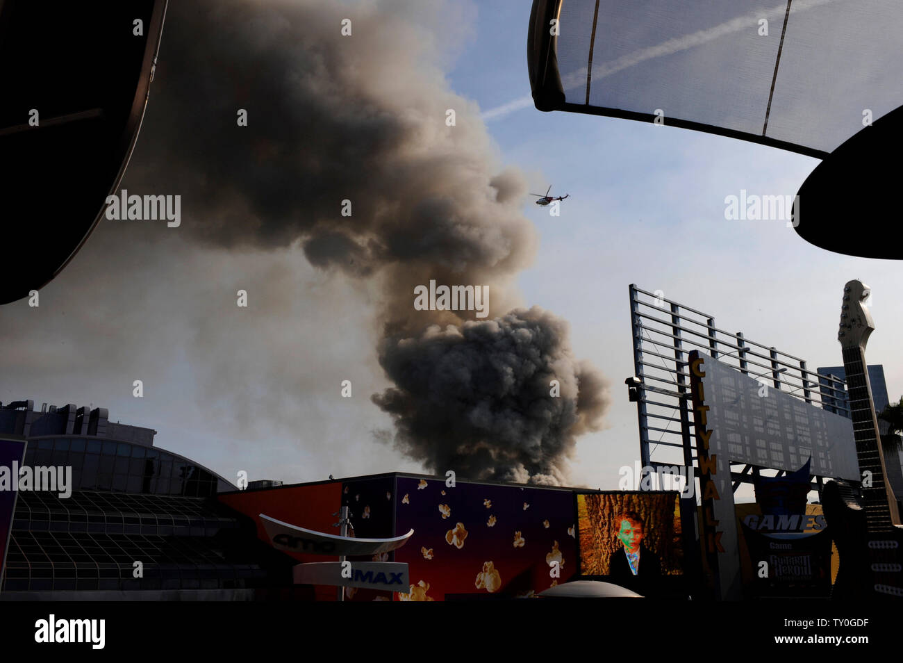Smoke billows over Universal Walk as a fire rages out of control on the ...