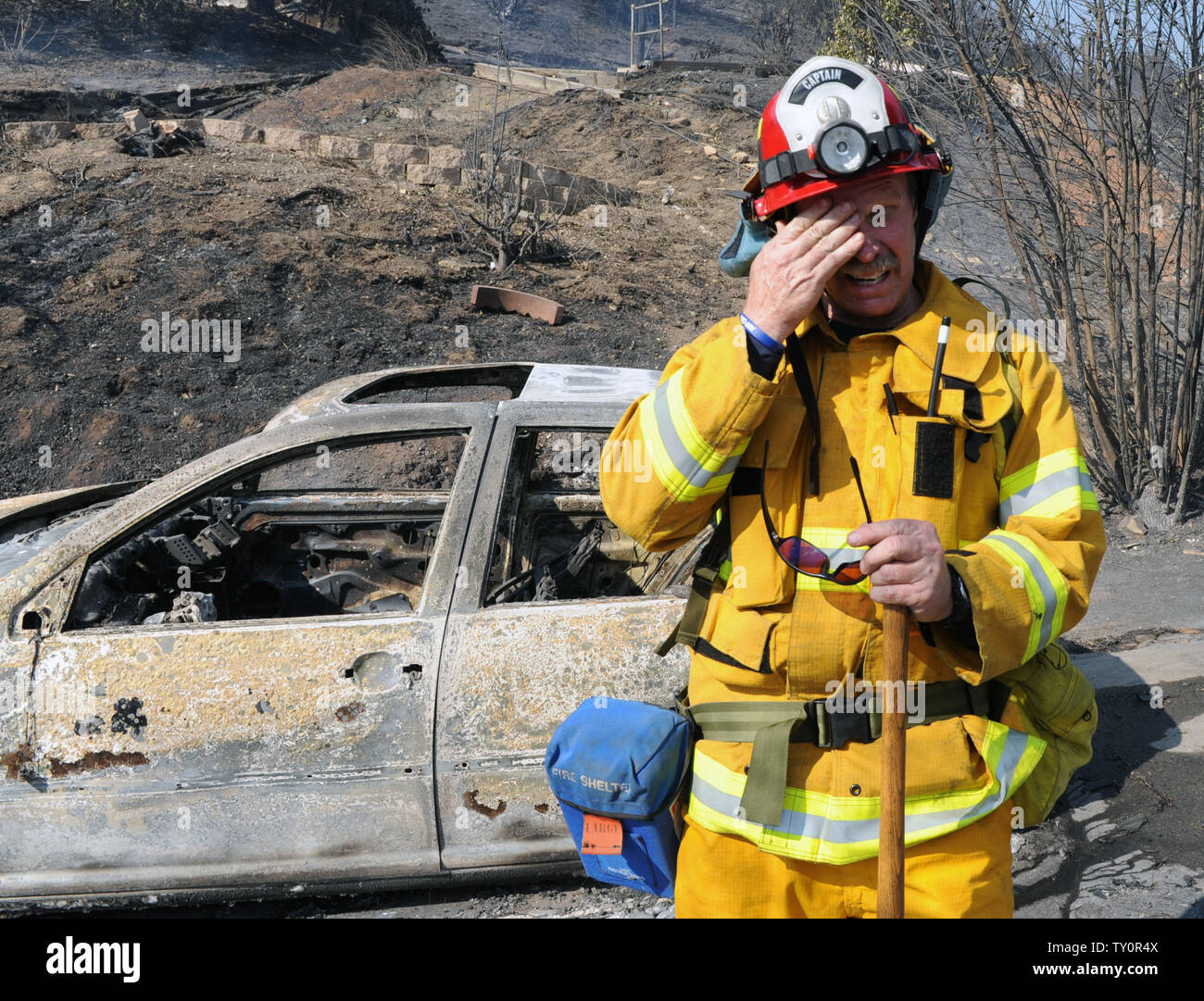 Captain David Calderwood rubs his eye, after a wildfire burned through ...