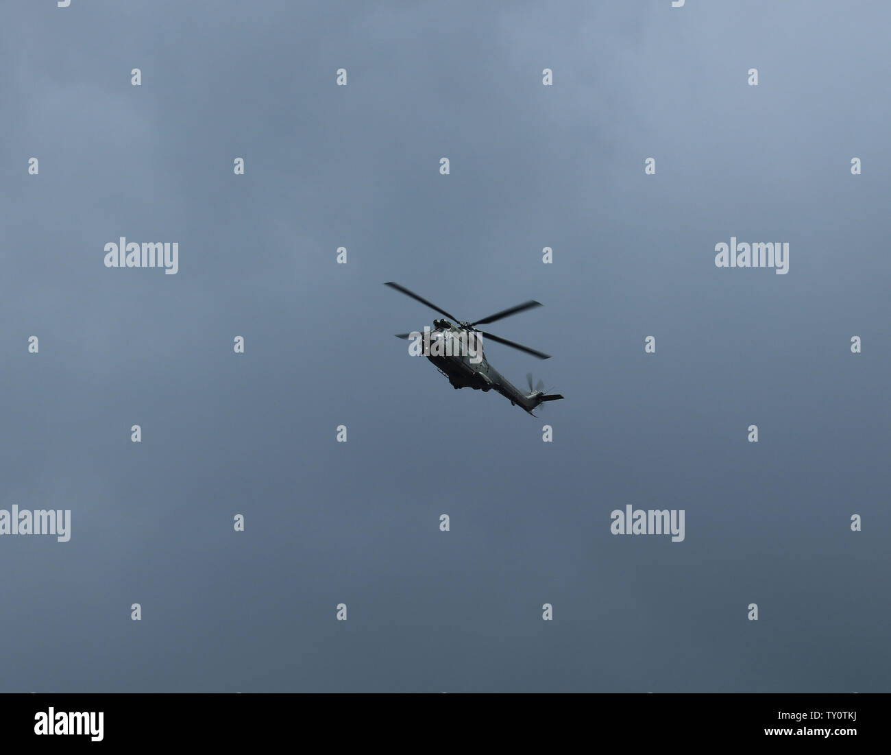 Helicopter flying over the Houses of Parliament on a grey and overcast ...
