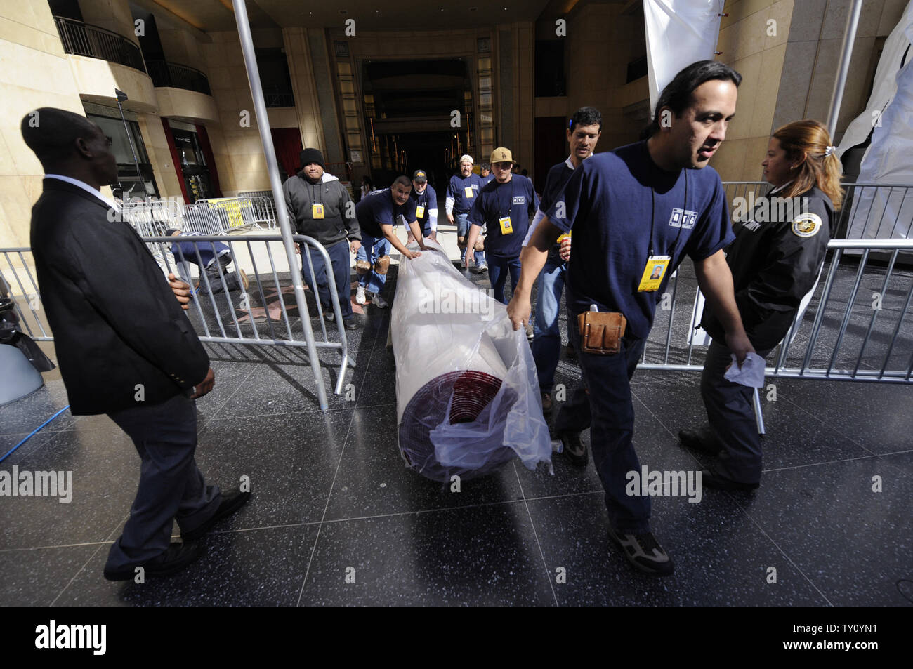 Workers carry a roll of red carpet as preparations continue for the ...